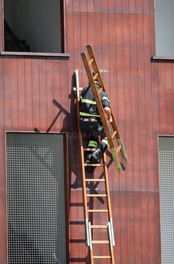 Firefighter in Action in the Fire Station with the Long Ladder Stock ...