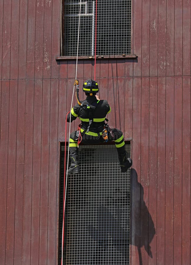 Firefighter Climbing a Building with a Safety Harness, Ropes Stock ...