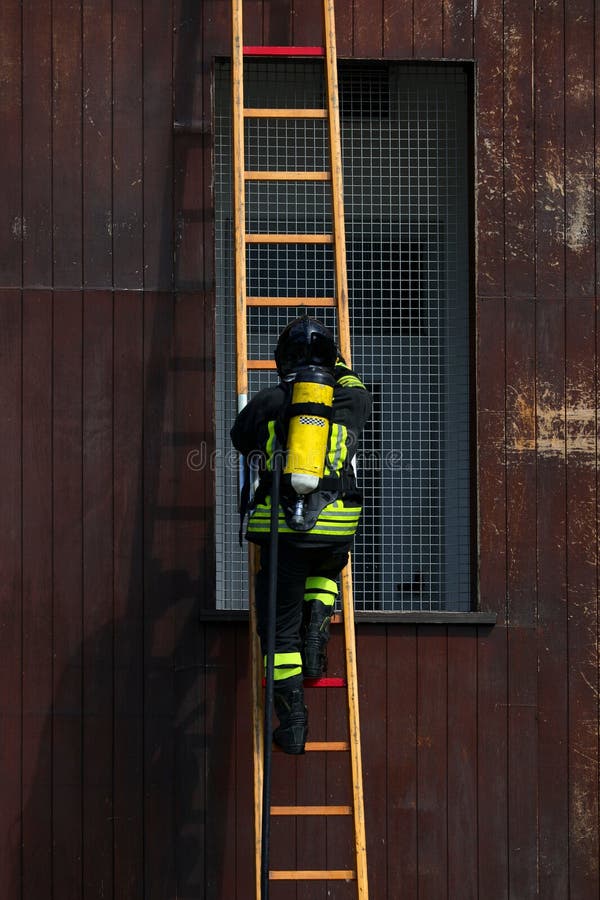 Firefighter Climbing a Ladder with an Oxygen Tank Stock Image - Image ...
