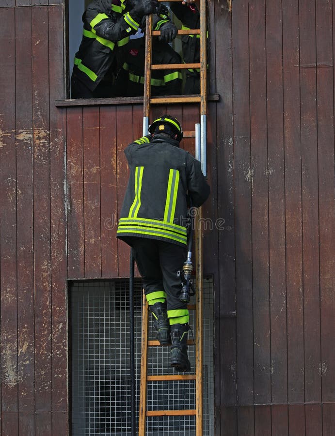 Firefighter is Climbing a Wooden Ladder during a Training Exercise at a ...