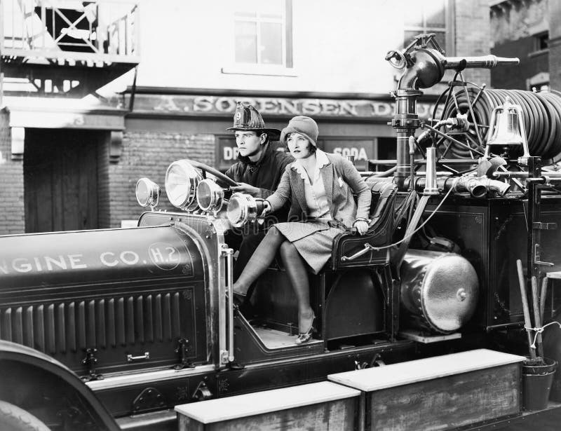 Firefighter Driving a Fire Engine and a Young Woman Sitting beside Him ...