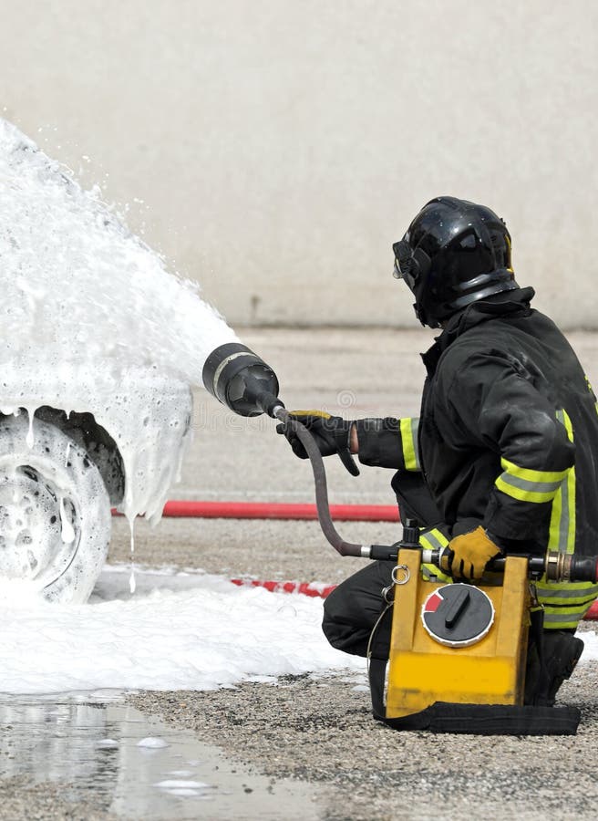 Firefighter Extinguishing a Car Fire Using a Special White Flame Stock ...