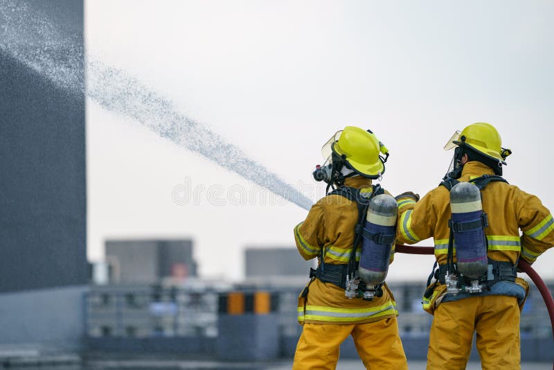 Firefighter or Fireman Team Work Water Spray by High Pressure Nozzle To ...