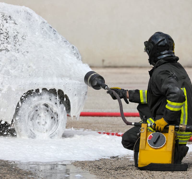 Firefighter with a Foam Extinguish the Fire in the Car after the ...