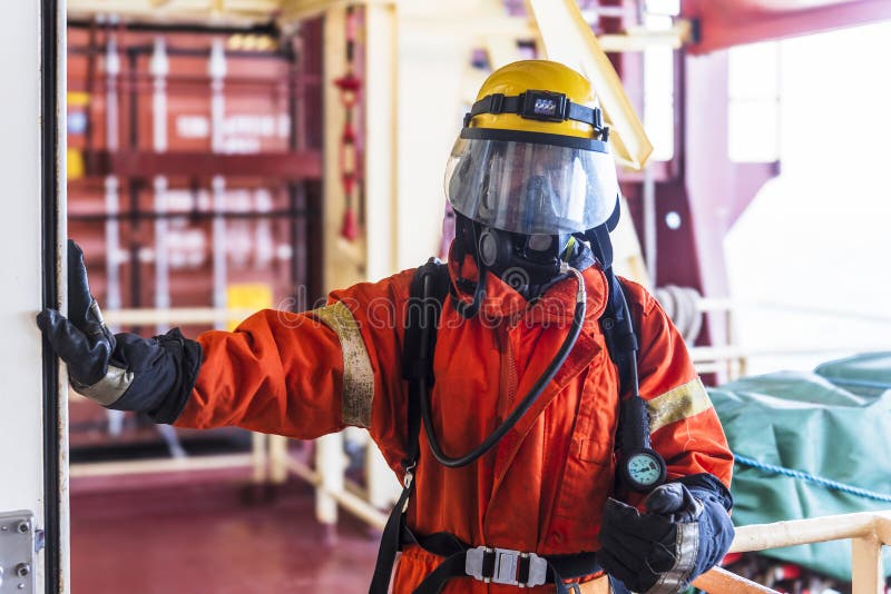 A Firefighter in Full Protective Gear, Mask, and Oxygen Tank Stands ...