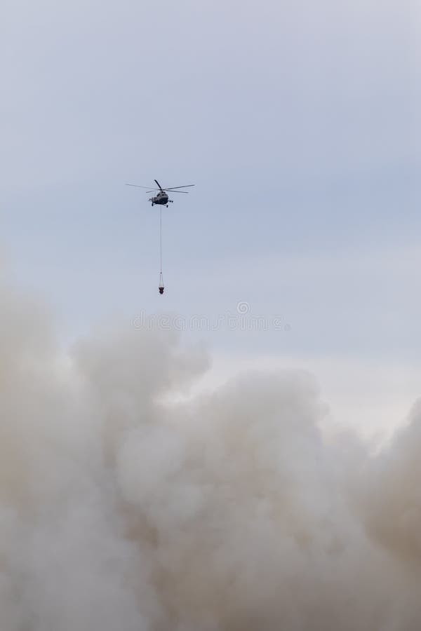Firefighter Helicopter with a Water Tank in Smoke from a Fire Stock ...