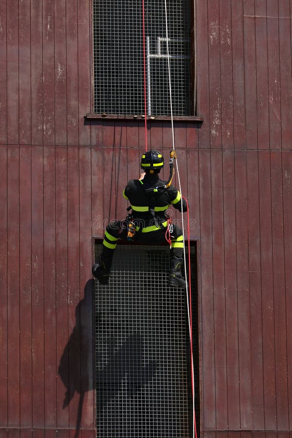 Firefighter with Helmet and Uniform Lowering Himself Down from the ...