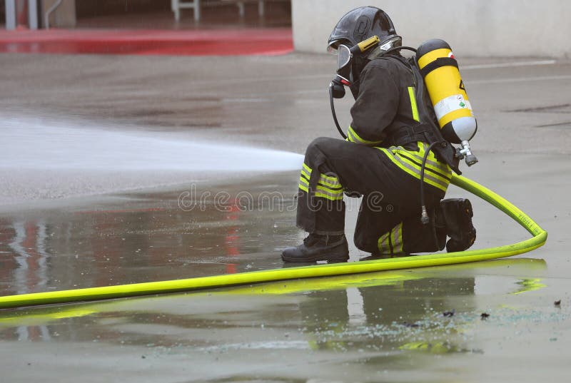 Firefighter with a Hose Spraying Foam Extinguishing Agent and an Oxygen ...