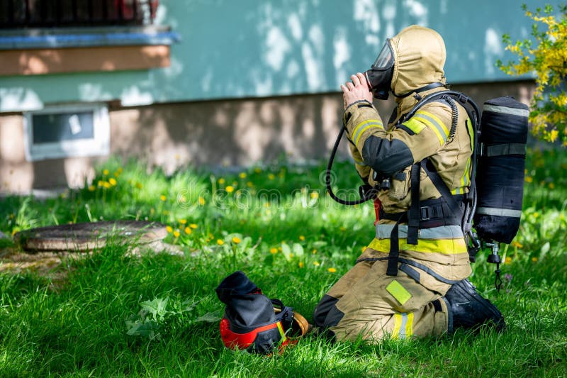 A Brave Firefighter in Protective Gear is Assessing the Environment for ...