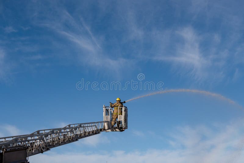 Firefighter on Ladder, Spraying Water on Fire, Side View Editorial ...