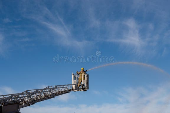 Firefighter on Ladder, Spraying Water on Fire, Side View Editorial ...