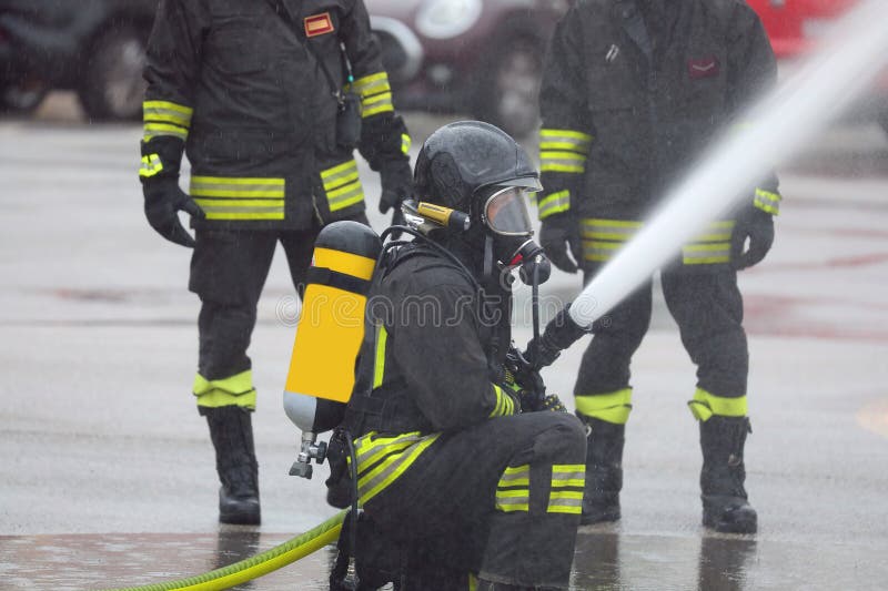 Firefighter with Mask and Oxygen Tank Spraying Extinguishing Foam ...