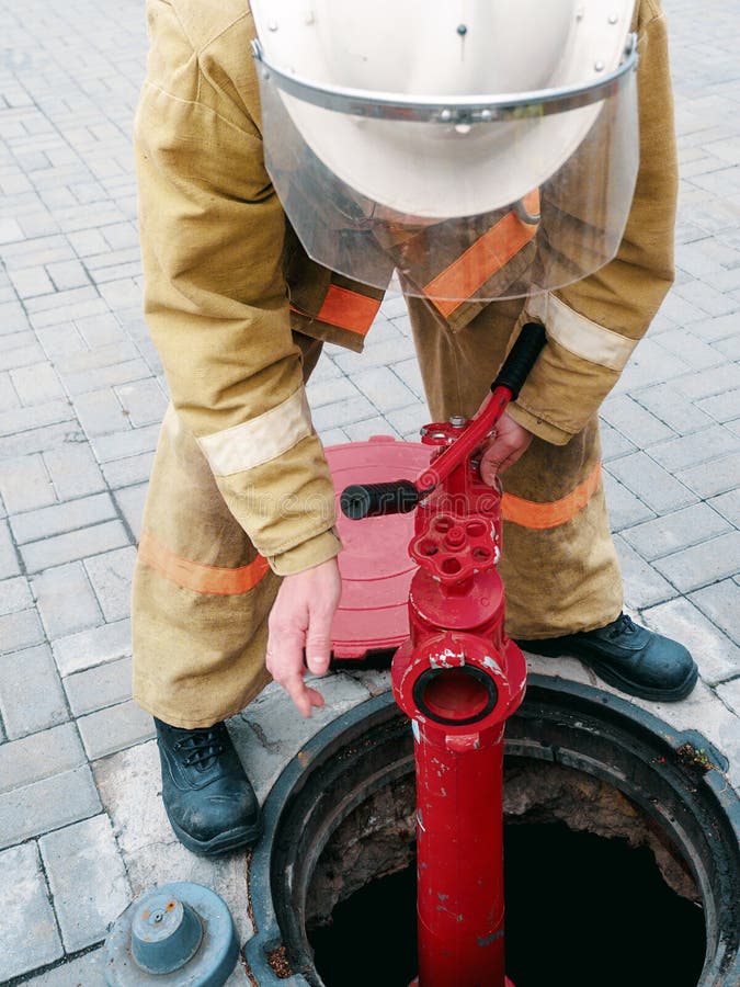 Firefighter or Rescuer Installs Fire Hydrant in Open Well. Fireman S ...