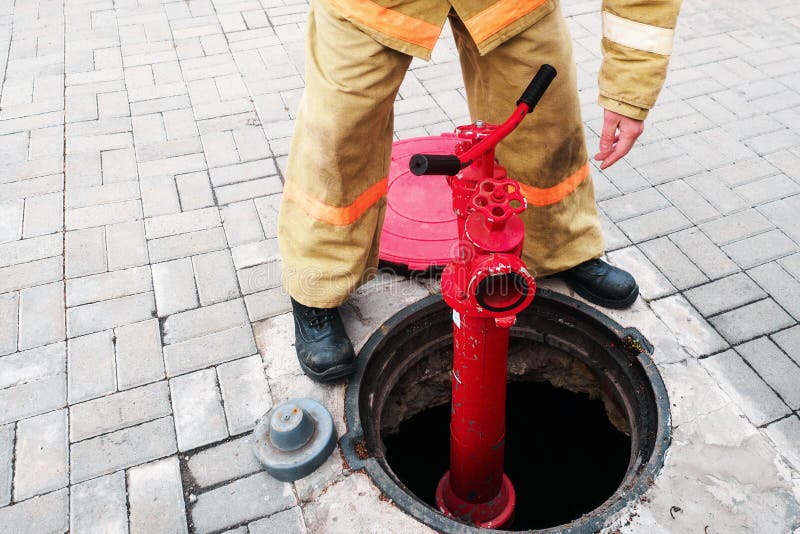 Firefighter or Rescuer Installs Fire Hydrant in Open Well. Fireman& X27 ...
