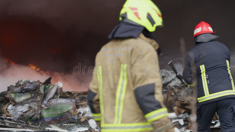 Fireman in Safety Uniform and Helmet Removing Flammable Material with a ...