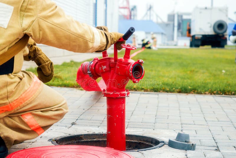 Firefighter Sits Next To Fire Hydrant. Back View Stock Photo - Image of ...
