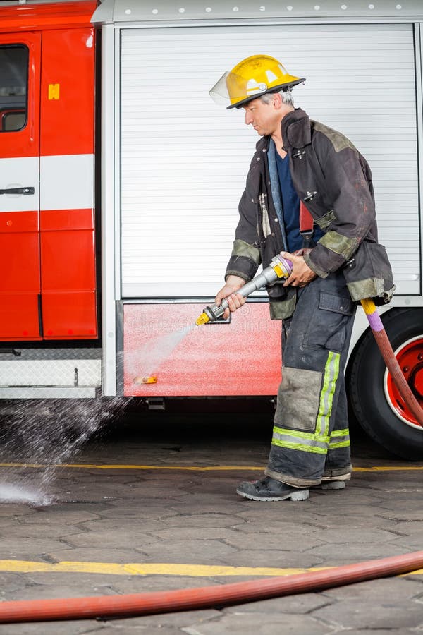 Firefighter Spraying Water on Floor during Stock Photo - Image of ...