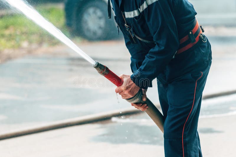 Firefighter Spraying Water from the Hose Stock Image - Image of pipe ...
