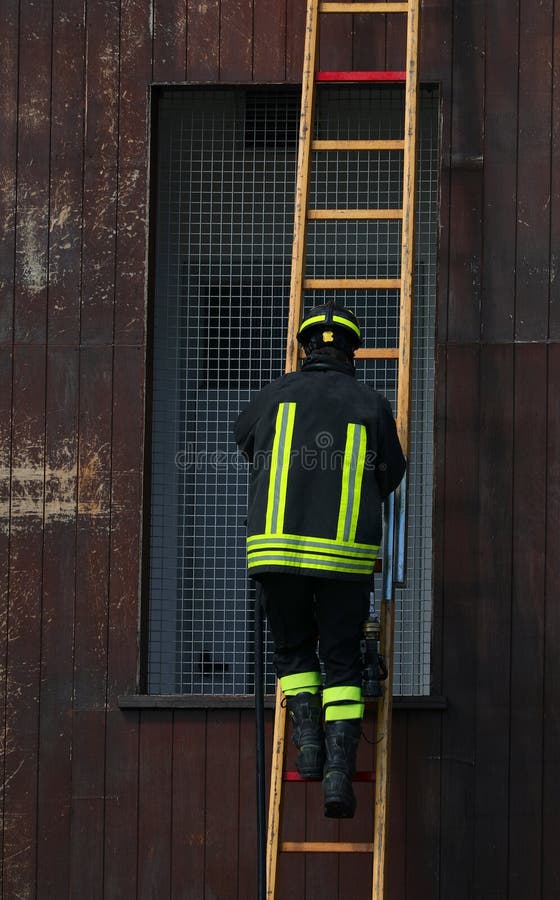 Firefighter in Uniform Climbing Ladder during Training at Fire Station ...