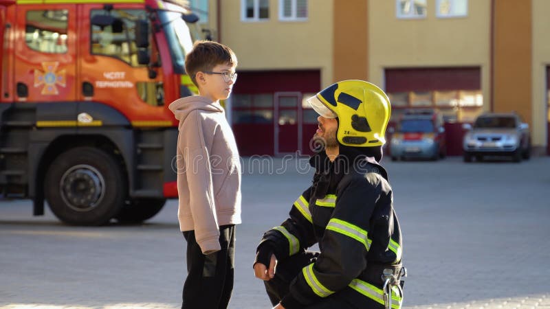 Firefighter in Uniform is with a Little Boy at Fire Station Stock Video ...