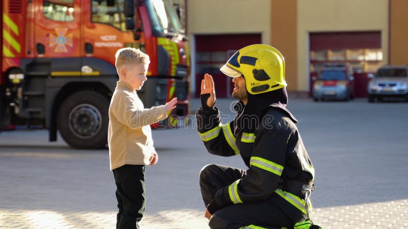 Firefighter in Uniform is with a Little Boy at Fire Station Stock Video ...