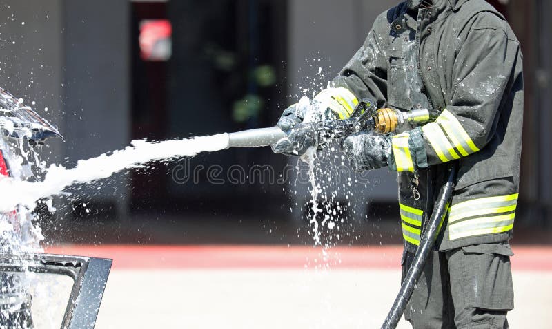 Firefighter Using a Hose To Spray Foam on a Fire during an Urban ...