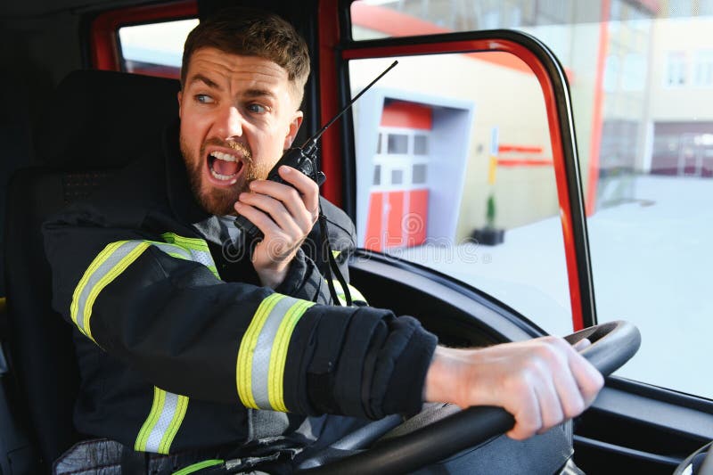 Firefighter Using Radio Set while Driving Fire Truck Stock Photo ...