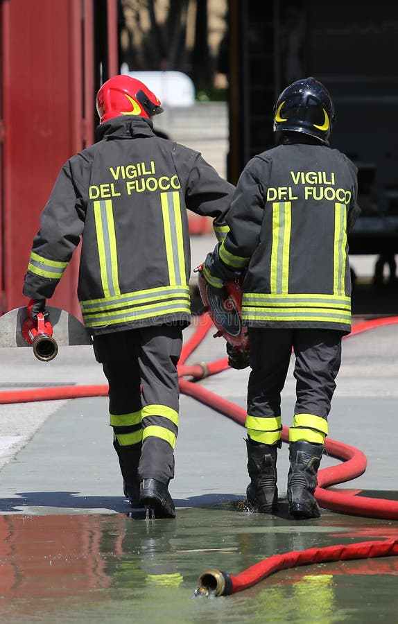 Two Firefighters Carry the Hydrant and Hose Pipes Stock Photo - Image ...