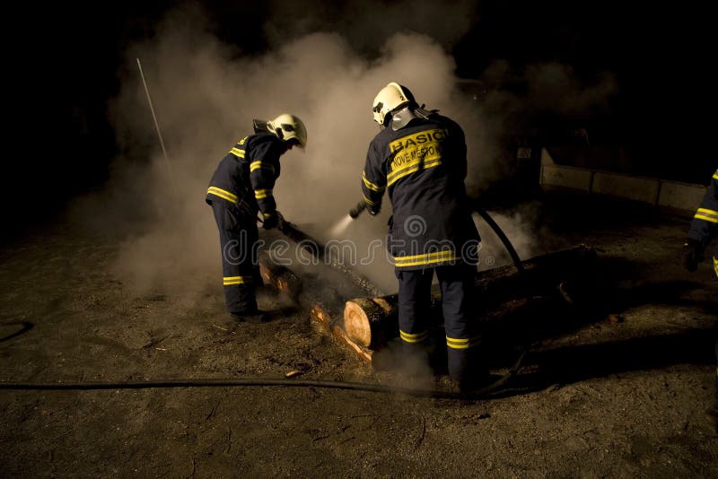 A Group of Firefighters Extinguishing a Fire at Night. Stock Photo ...