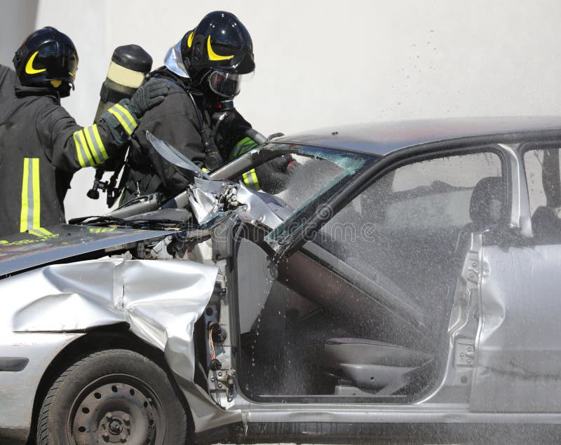 Firefighters during Fire Fighting of a Car after a Car Accident Stock ...