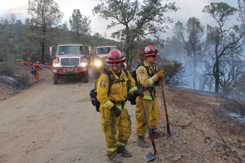 Line of Firefighters Standing with Hose in Front of a Burning Structure ...
