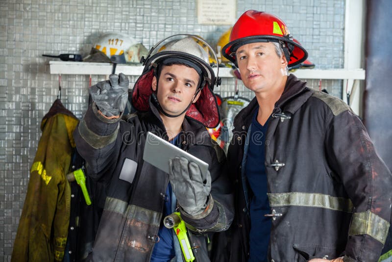 Firefighters Looking Away while Digital Tablet Stock Image - Image of ...