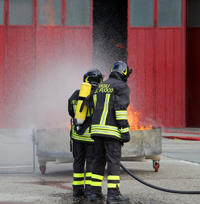 Firefighters With Oxygen Tank Extinguishing A Fire With Foam Stock ...