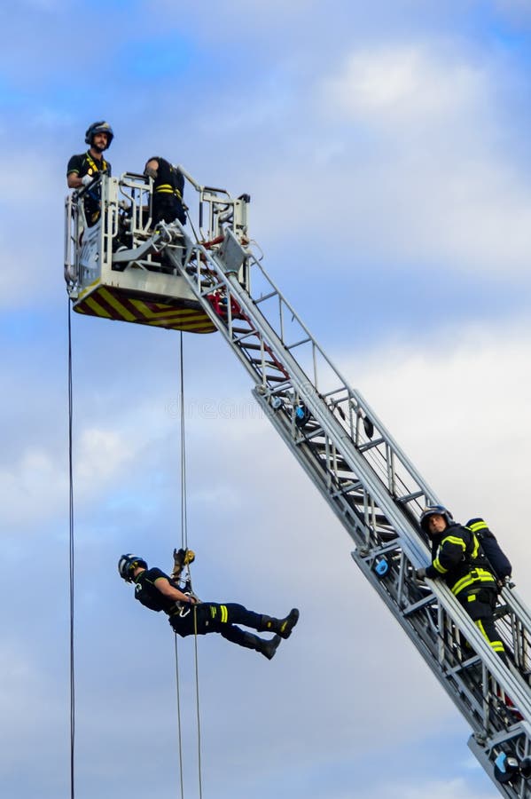 Firefighters on Rear Platform and a Firefighter Going Down a Rope ...