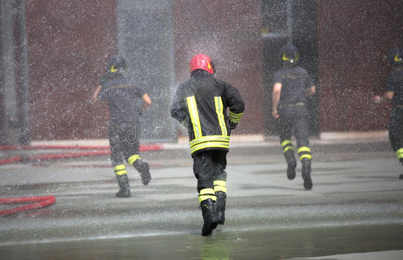 Firefighters Run Under the Splashes of Water during Fire Extingu Stock ...