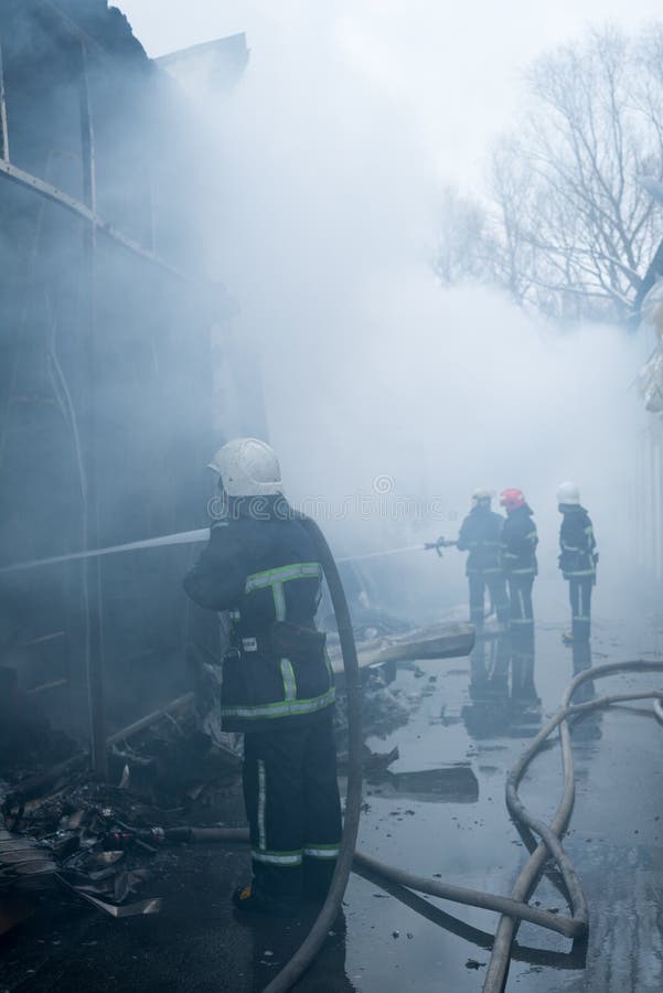 Firefighters Spray Water. Smoke and Buiding after Fire Editorial Stock ...