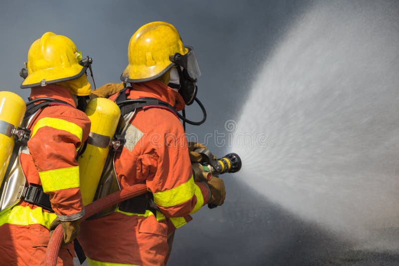 2 Firefighters Spraying Water in Fire Fighting with Dark Smoke B Stock ...