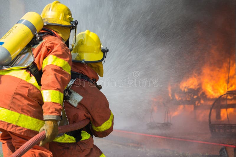 2 Firefighters Spraying Water in Fire Fighting Operation Stock Image ...
