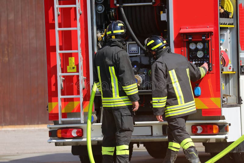 Firefighters with Uniform and Red Fire Truck during Emergency Stock ...