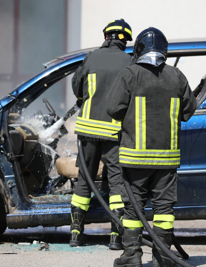 Firefighters Wearing Protective Helmets and Uniforms Extinguishing the ...