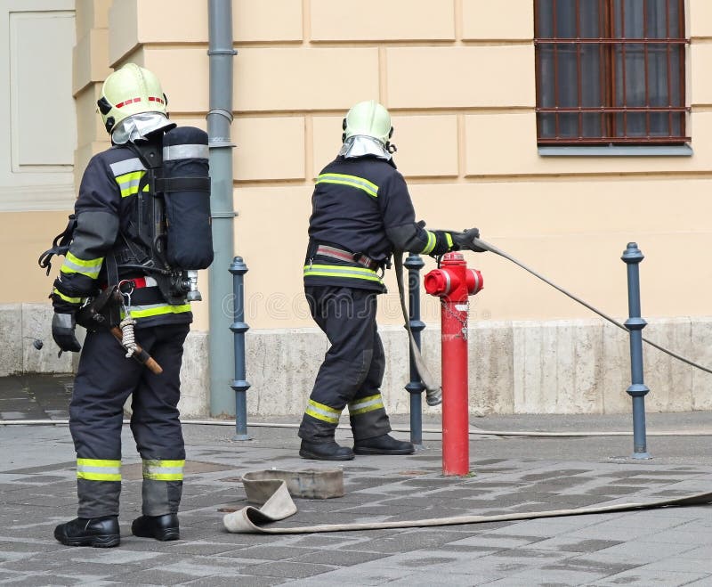 Firefighters at Work with Hose and Oxygen Tank Stock Image - Image of ...