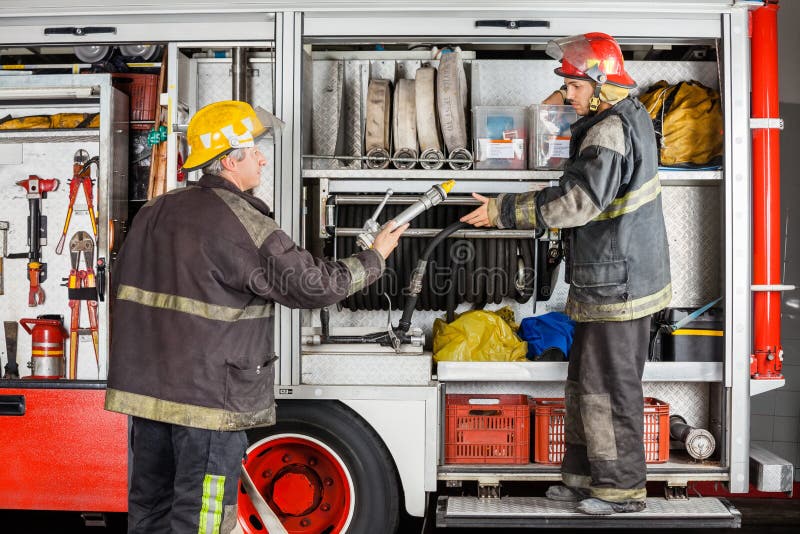 Firefighters Working at Truck in Fire Station Stock Image - Image of ...