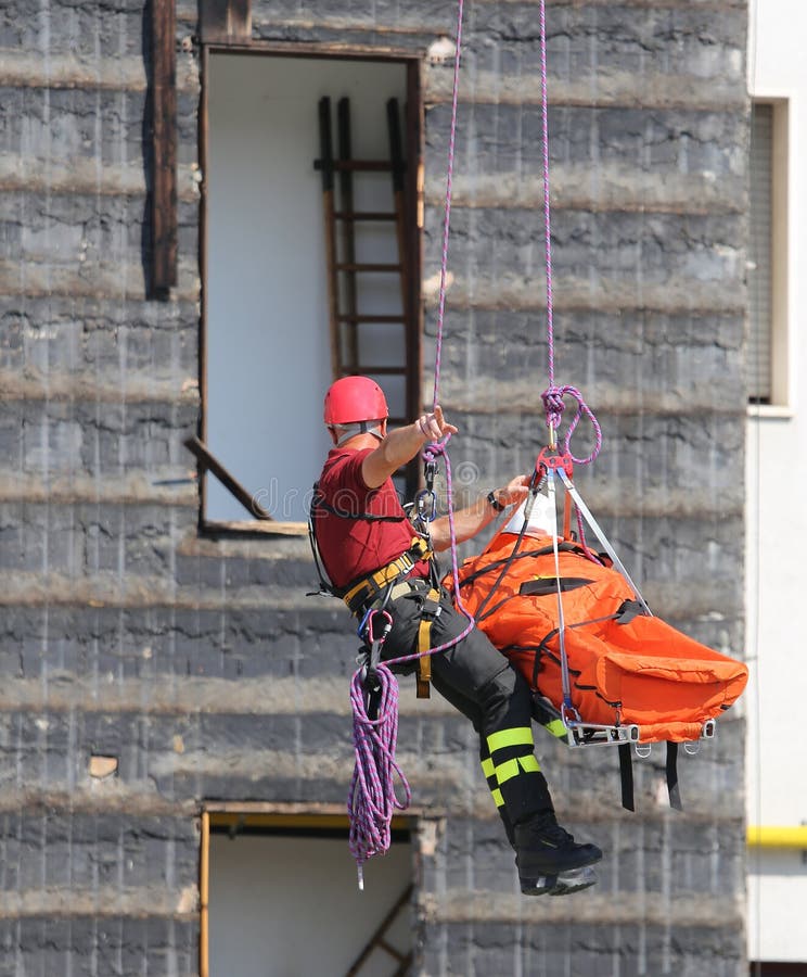 Fireman during an Exercise Carries the Stretcher with the Climbing Rope ...