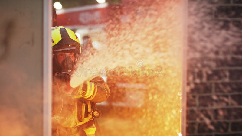 Fireman Extinguish Fire with the Hose. Burning House Fire Drill Stock ...
