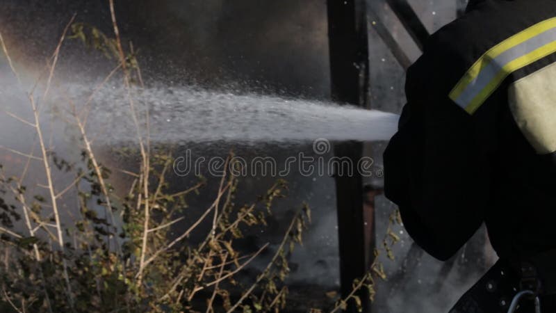 Fireman Extinguishes the Fire with a Water Jet Stock Video - Video of ...