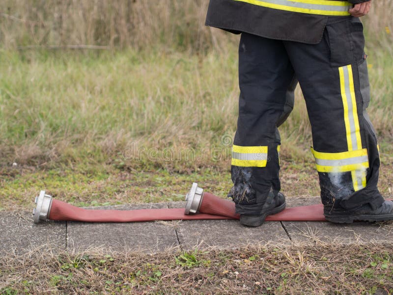 Fireman and fire hose editorial stock image. Image of brigade - 73906509