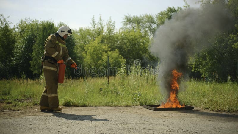 Fireman in Helmet and Protective Uniform Extinguishing the Fire that ...