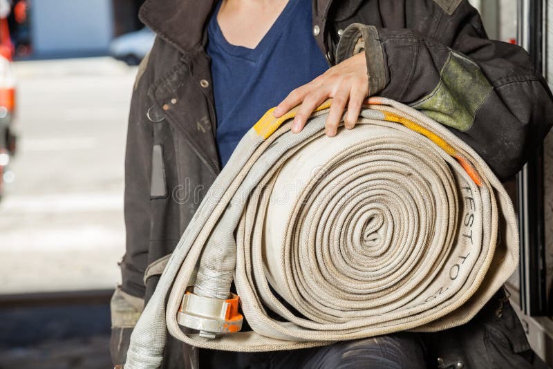 Fireman Holding Hose at Fire Station Stock Photo - Image of check ...