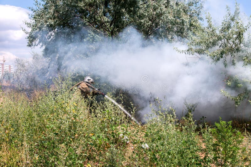 Fireman in a Protective Suit in a Cloud of Smoke Under Burning Pressure ...