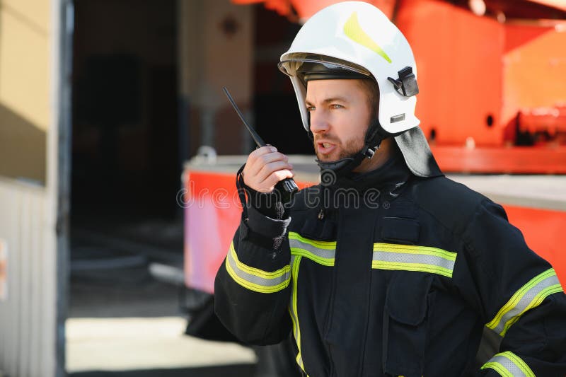 Fireman in a Protective Uniform Standing Next To a Fire Truck and ...